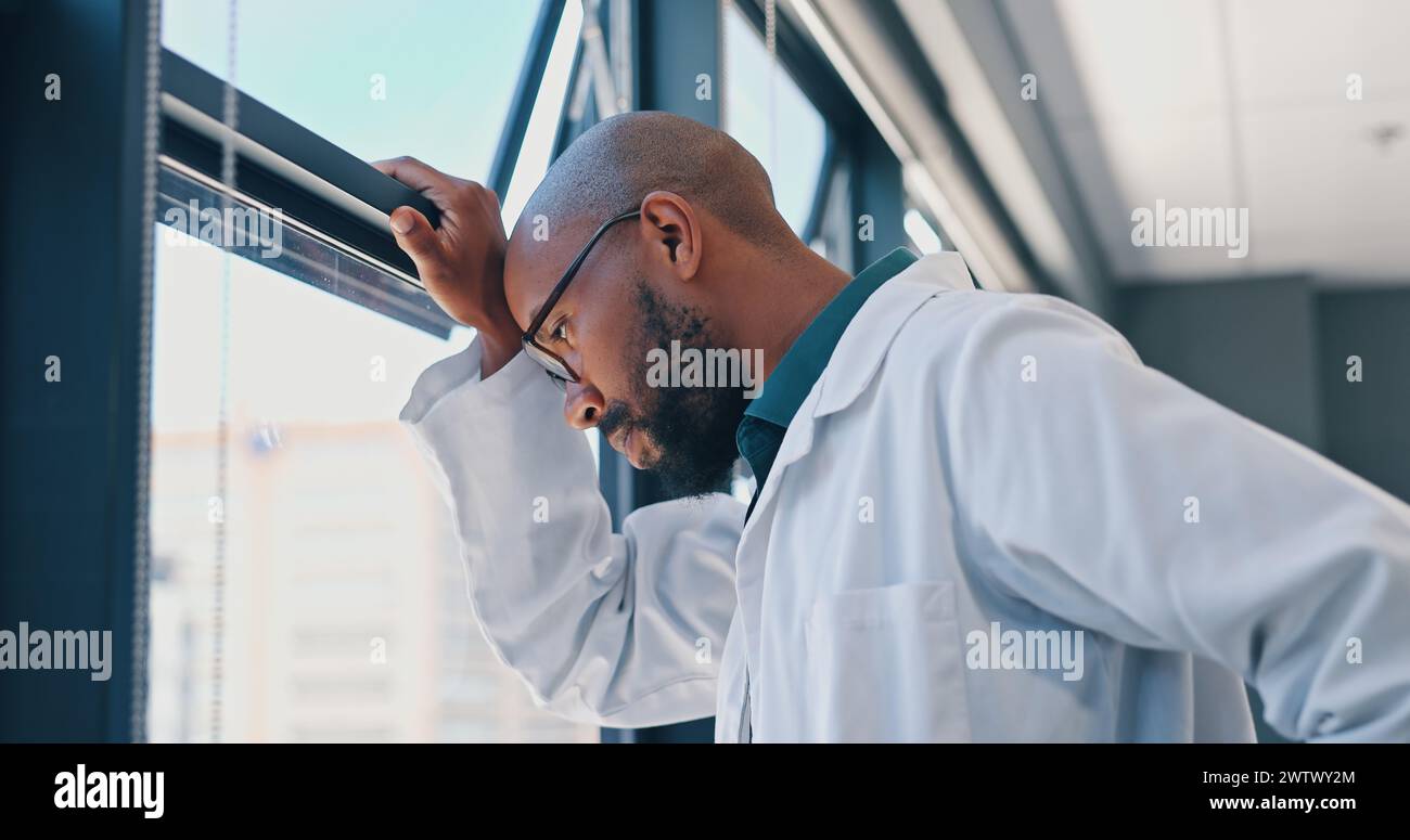 Doctor, healthcare and thinking at window of hospital with depression ...