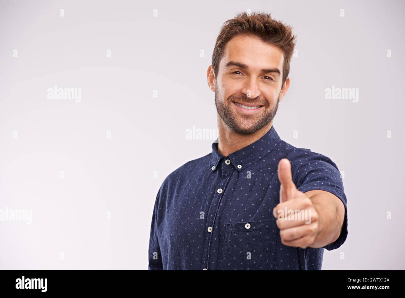 Support, portrait and man with thumbs up in studio, background and ...