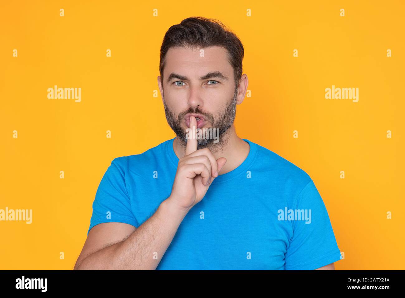 Guy having secret and holding finger on lips. Male model, asks to be ...
