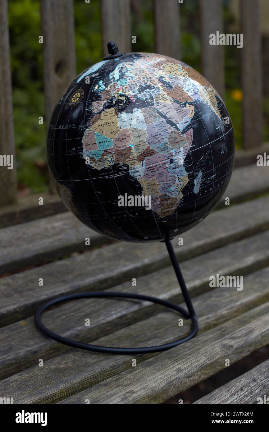 Vintage Earth globe on a wooden bench on the park. Europe, Africa, Asia ...