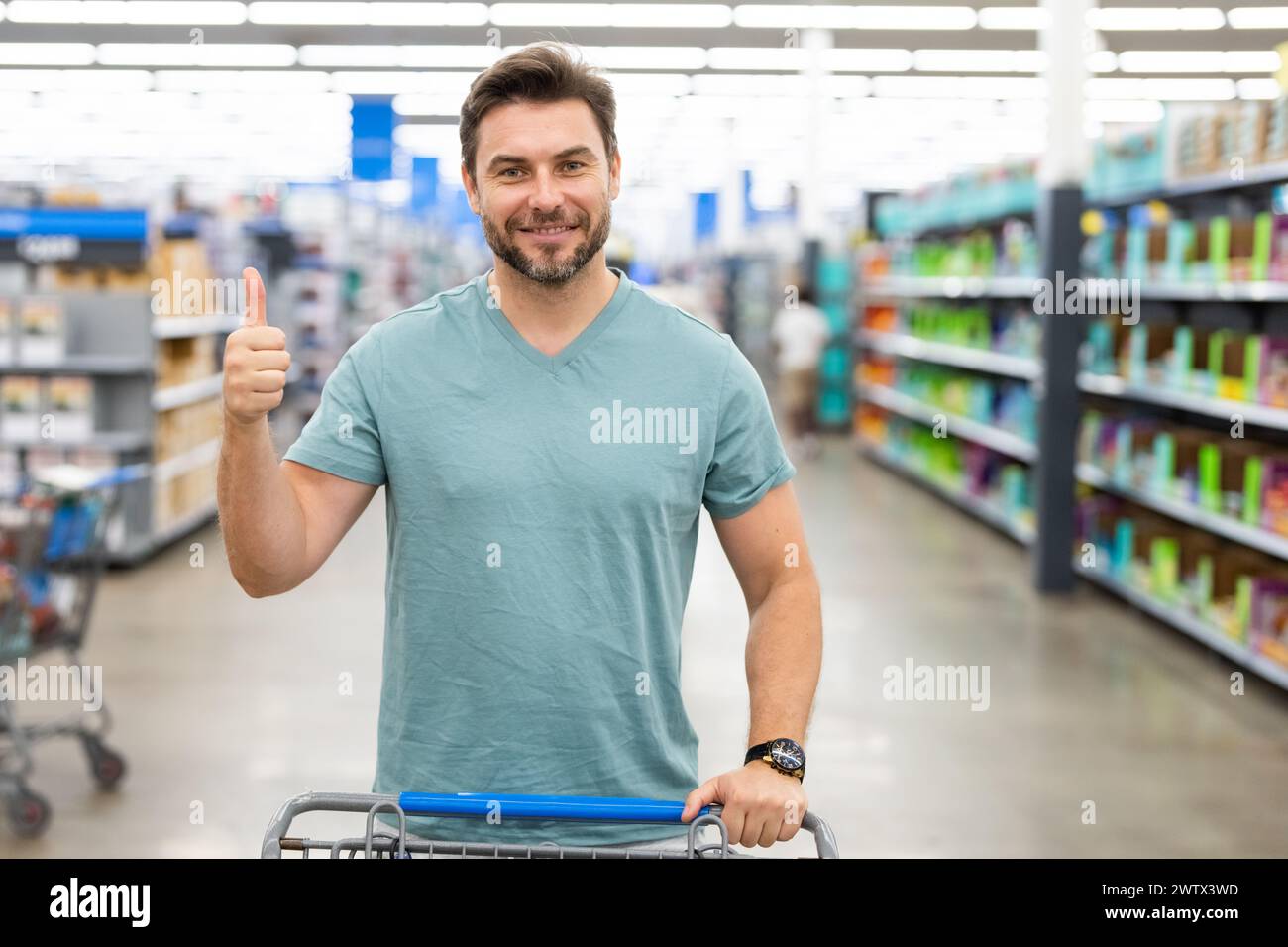 Man with thumb up in shop, market store. Man shopping in supermarket ...