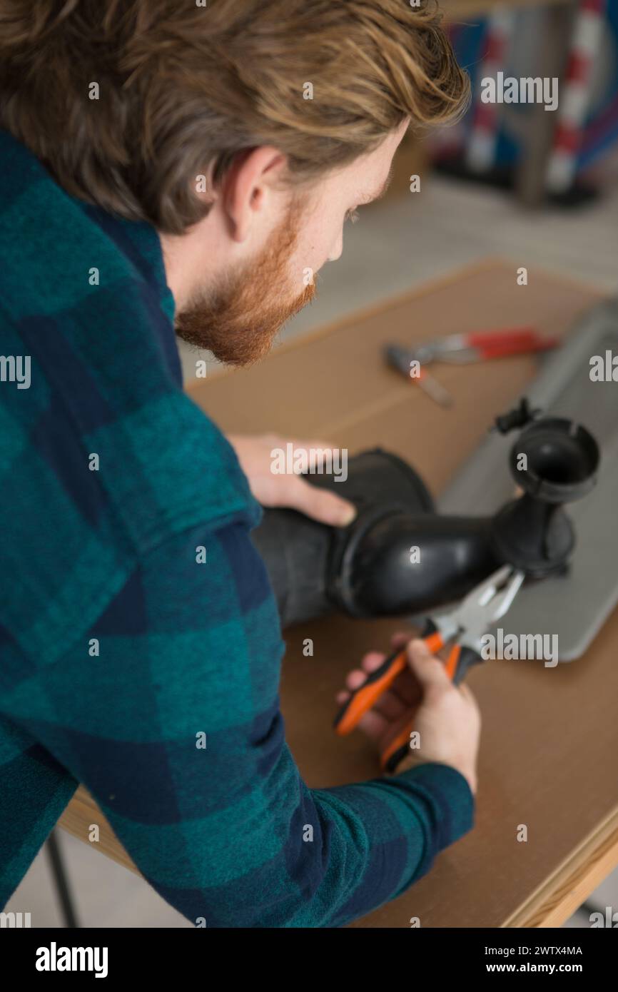 man fixing caster roller wheel of a wheel Stock Photo - Alamy