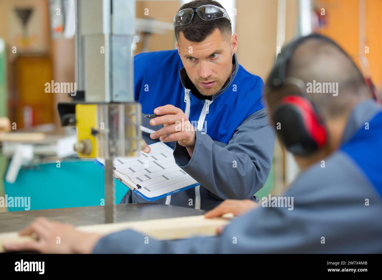 supervisor checking alignment of bench saw Stock Photo - Alamy