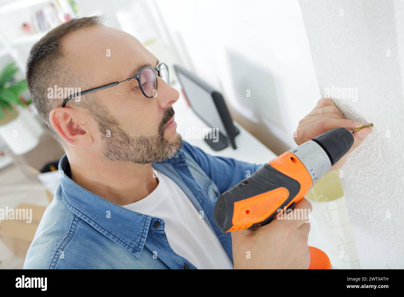 man drilling the wall with drill perforator Stock Photo - Alamy