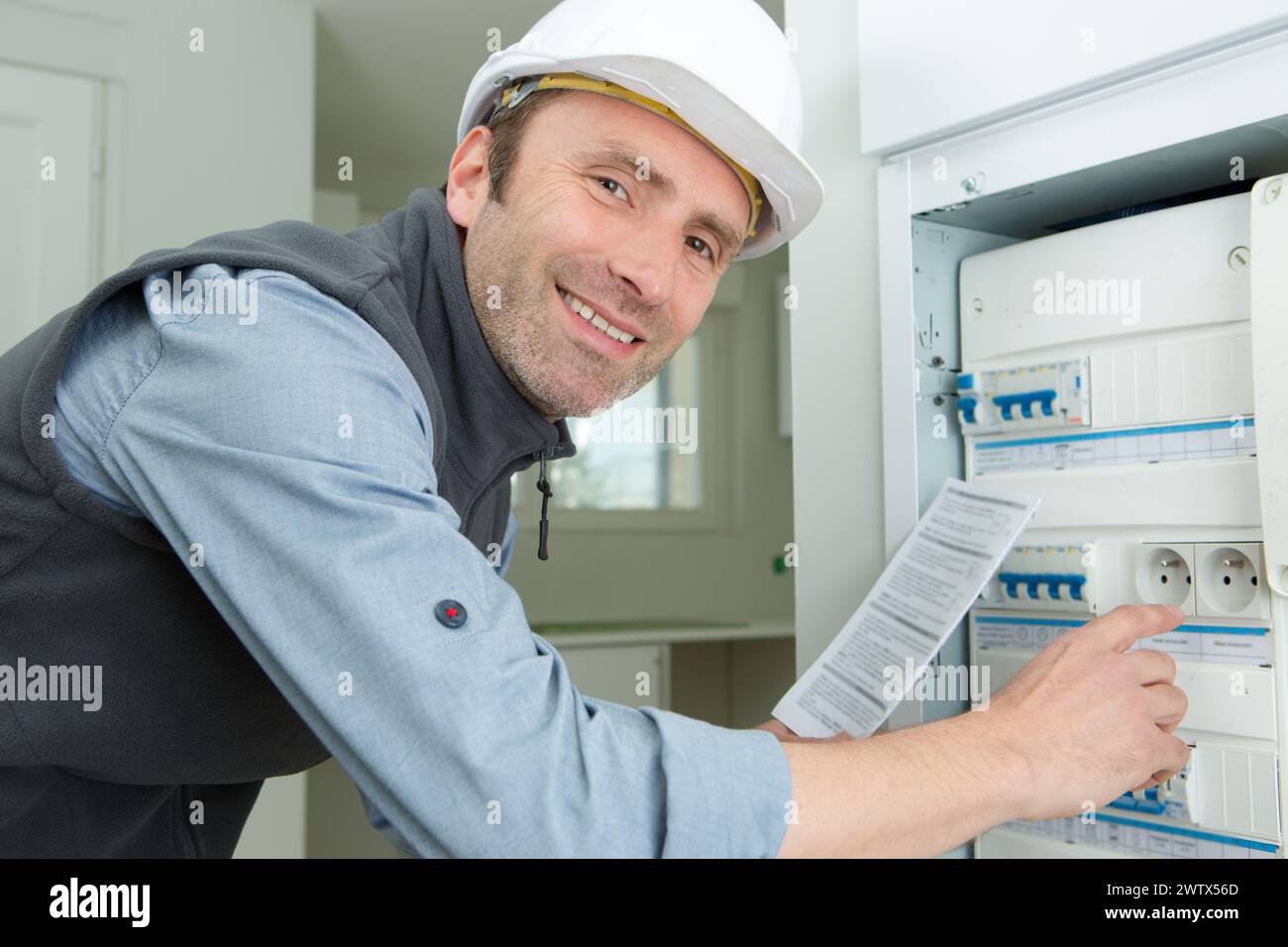 electrician posing next to electrical panel Stock Photo - Alamy