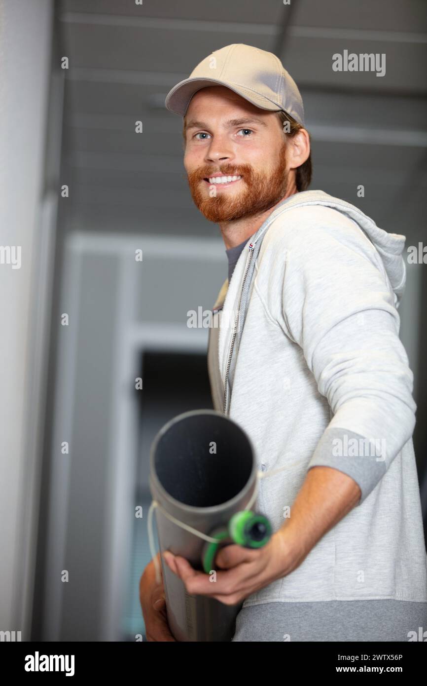 worker carrying pipe at construction site Stock Photo - Alamy