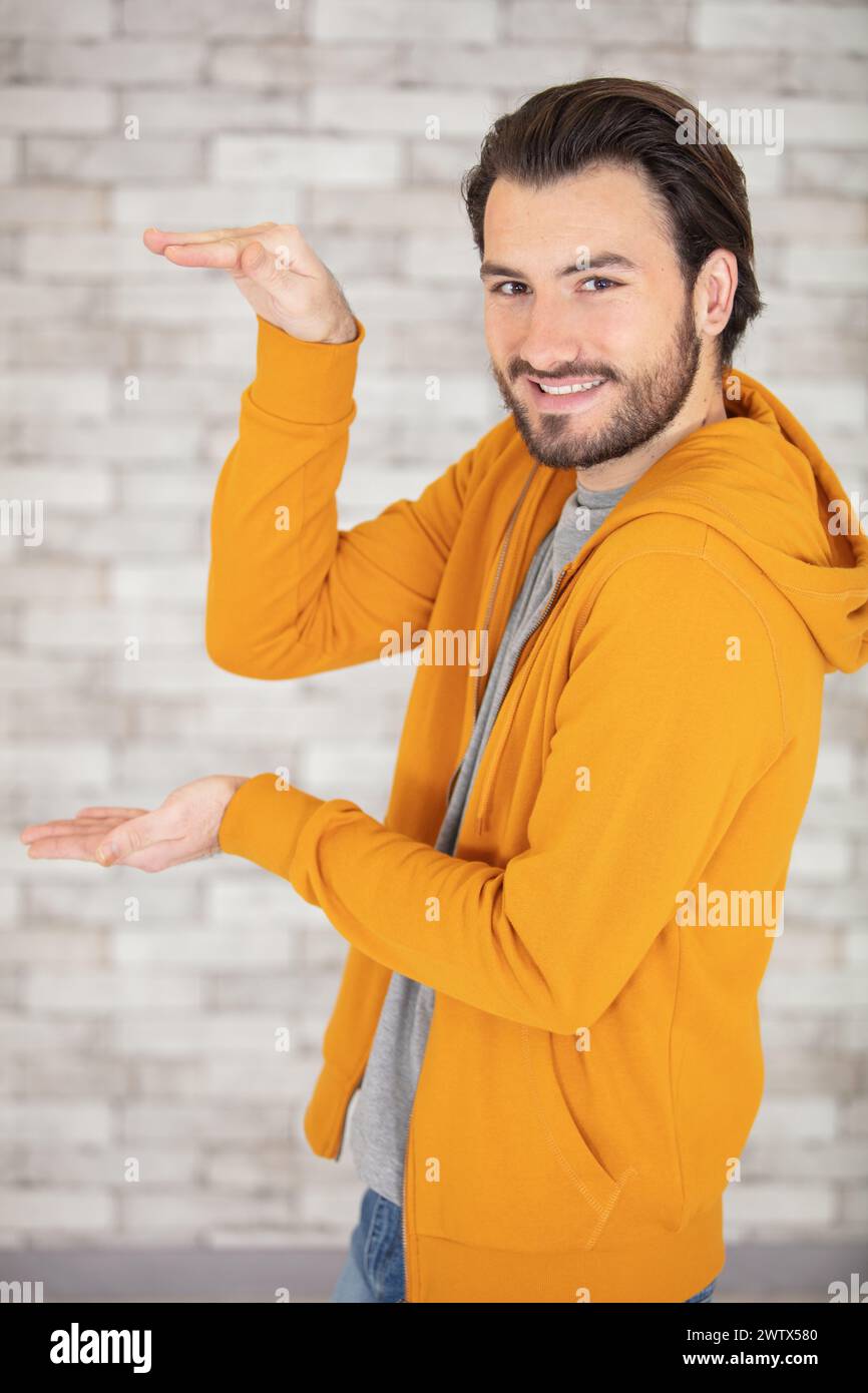 young man looking at hands showing something huge Stock Photo - Alamy