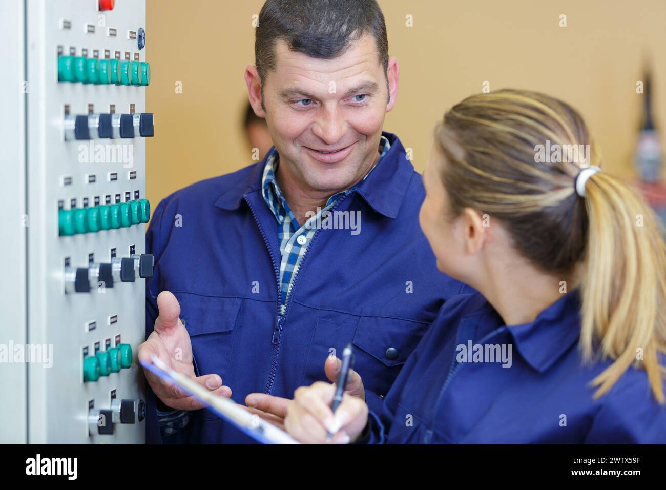 female factory intern holding clipboard talking to supervisor Stock ...