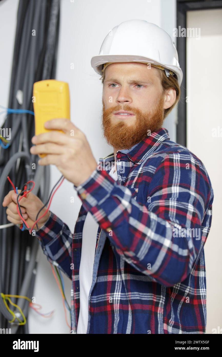 confident electrician mounting electrical wiring inside building Stock ...
