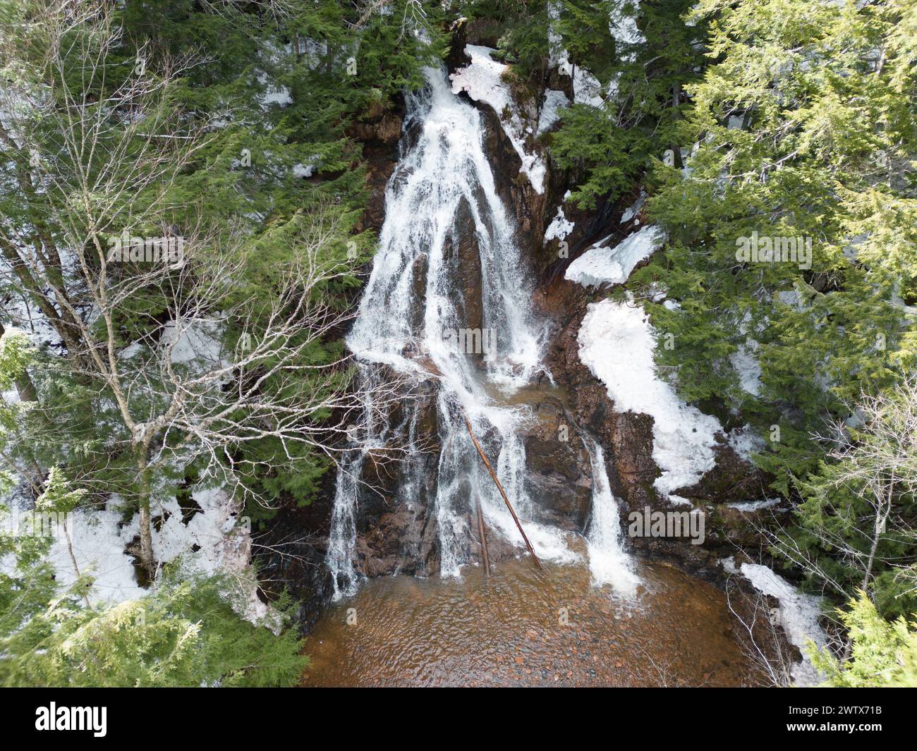 A scenic waterfall cascading over rocks in a forest setting Stock Photo ...