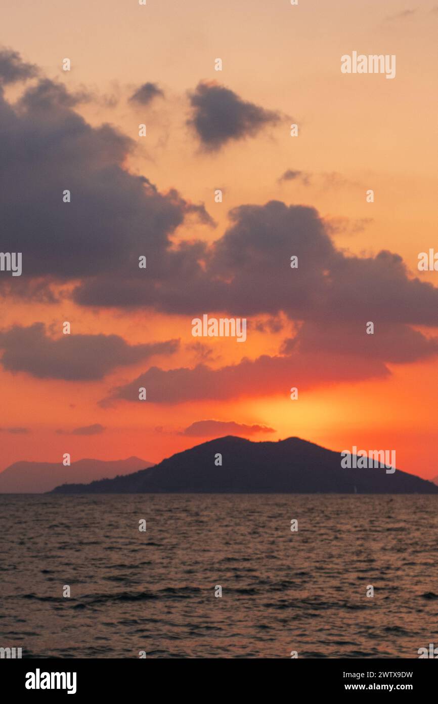 Red sky at morning, afterglow over ocean, mountain in distance Stock ...