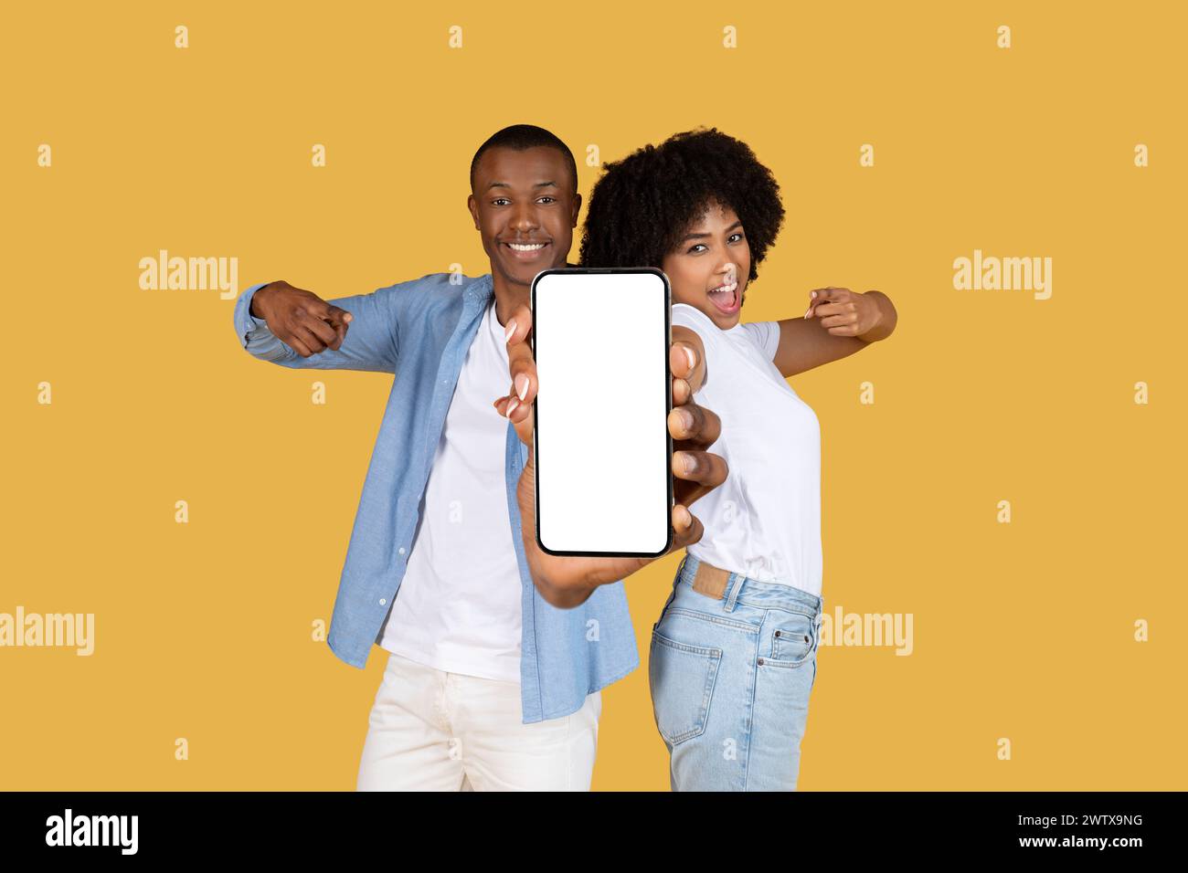 Excited African American couple presenting a smartphone with a blank ...
