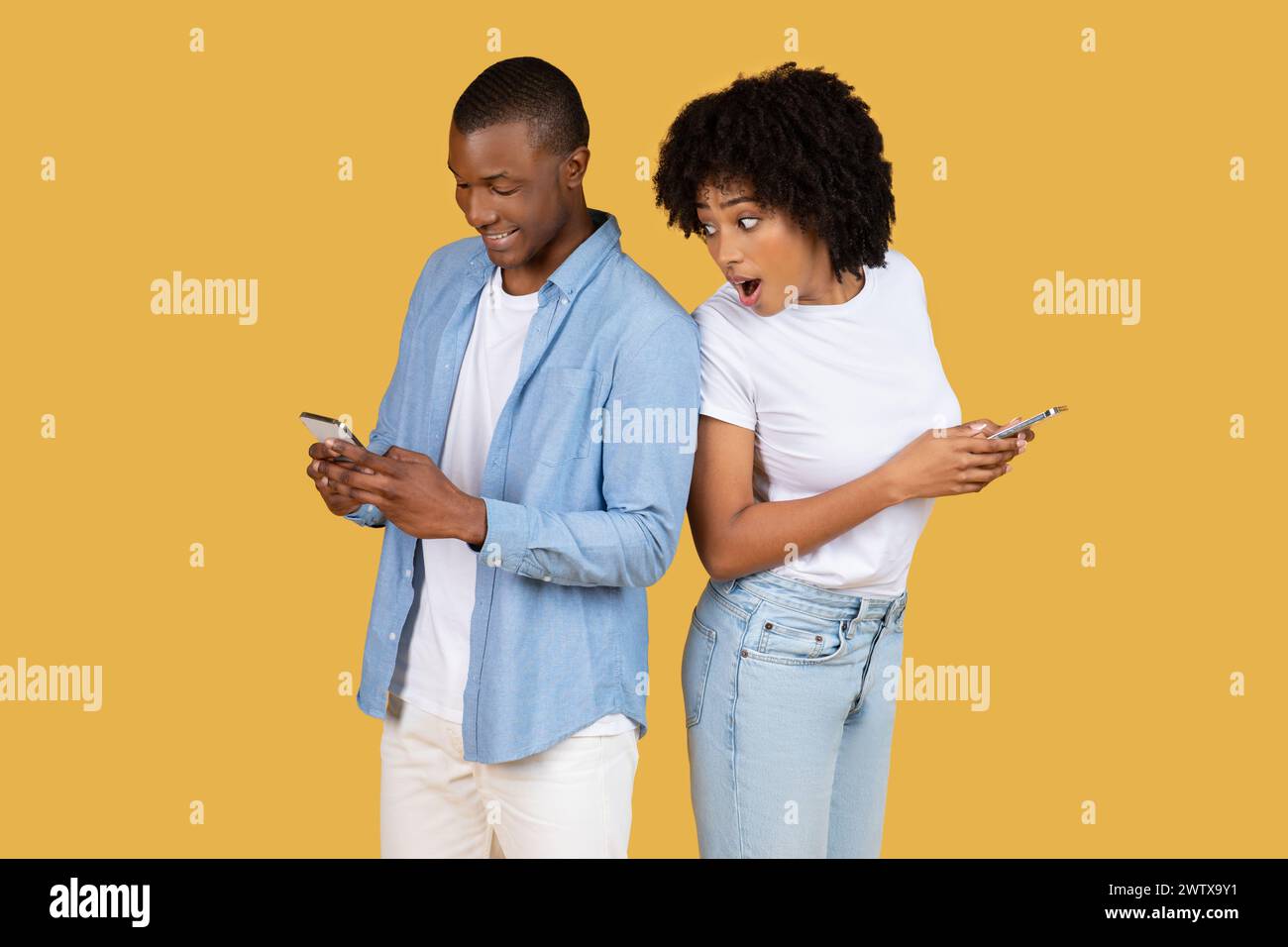 Surprised African American woman peeking over the shoulder of a focused ...