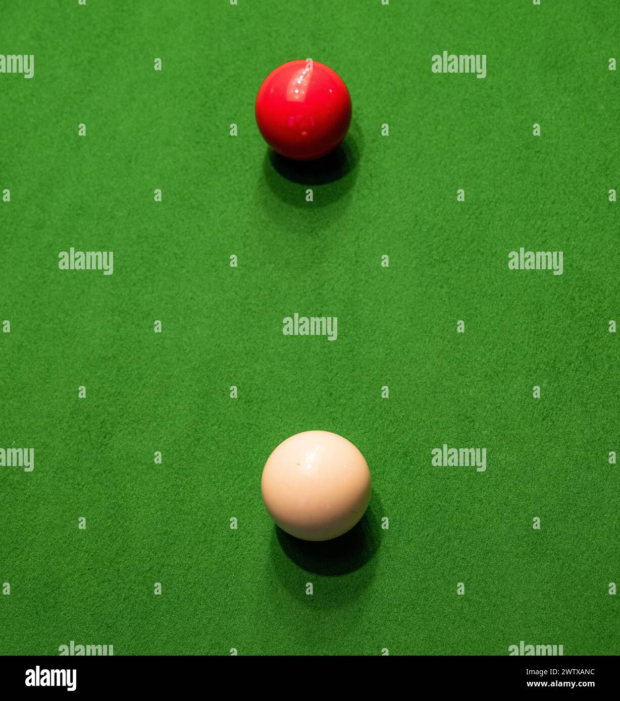 Red and white snooker balls on the green baize of a snooker table; a ...