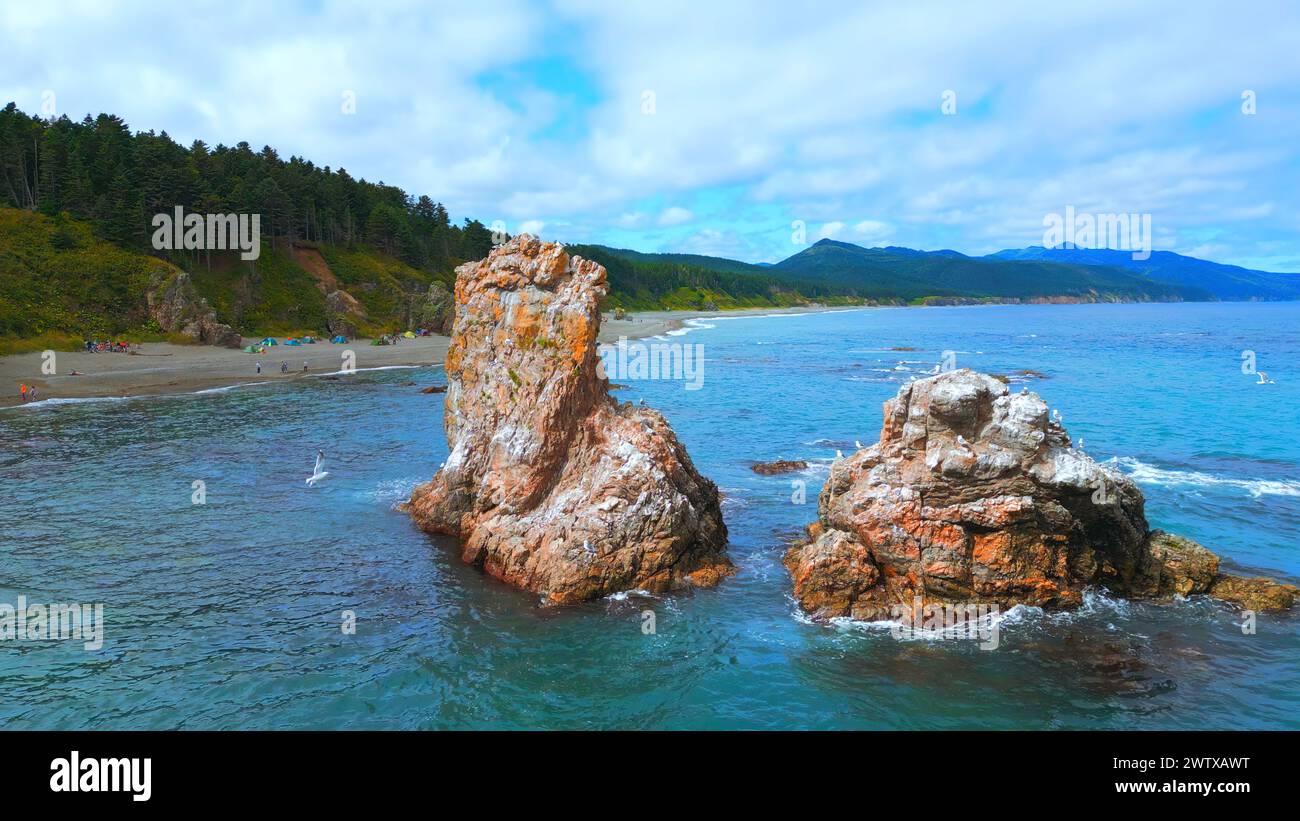 Top view of rocks in sea and coast with tourists. Clip. Beautiful coast ...