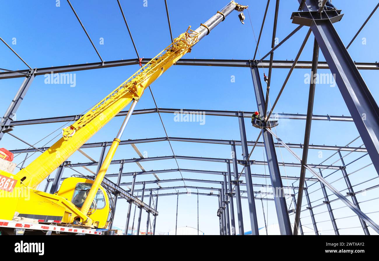 ZHANGYE, CHINA - MARCH 19, 2024 - Construction workers hoist steel ...