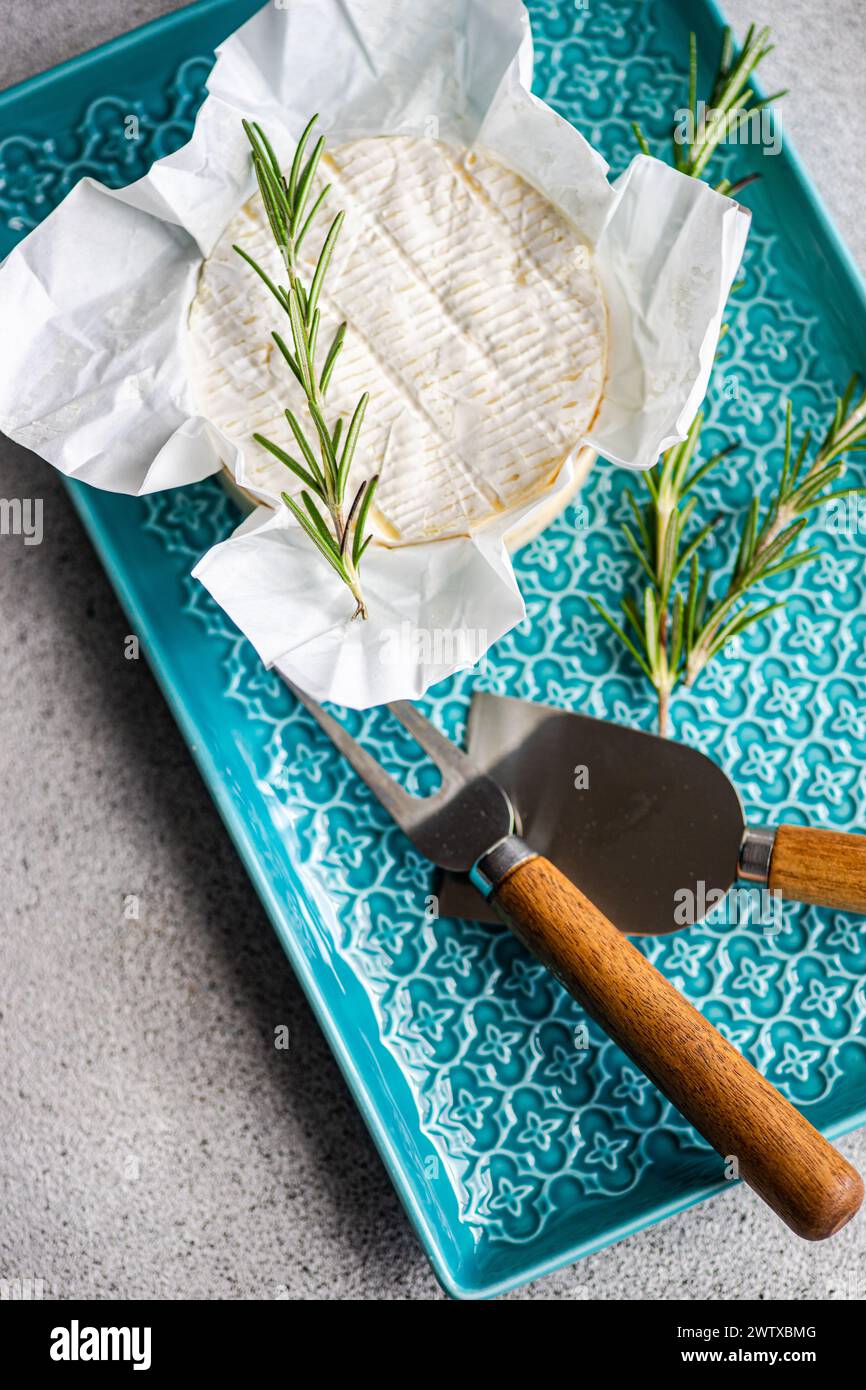 Overhead view of a whole brie with fresh rosemary on a plate with ...