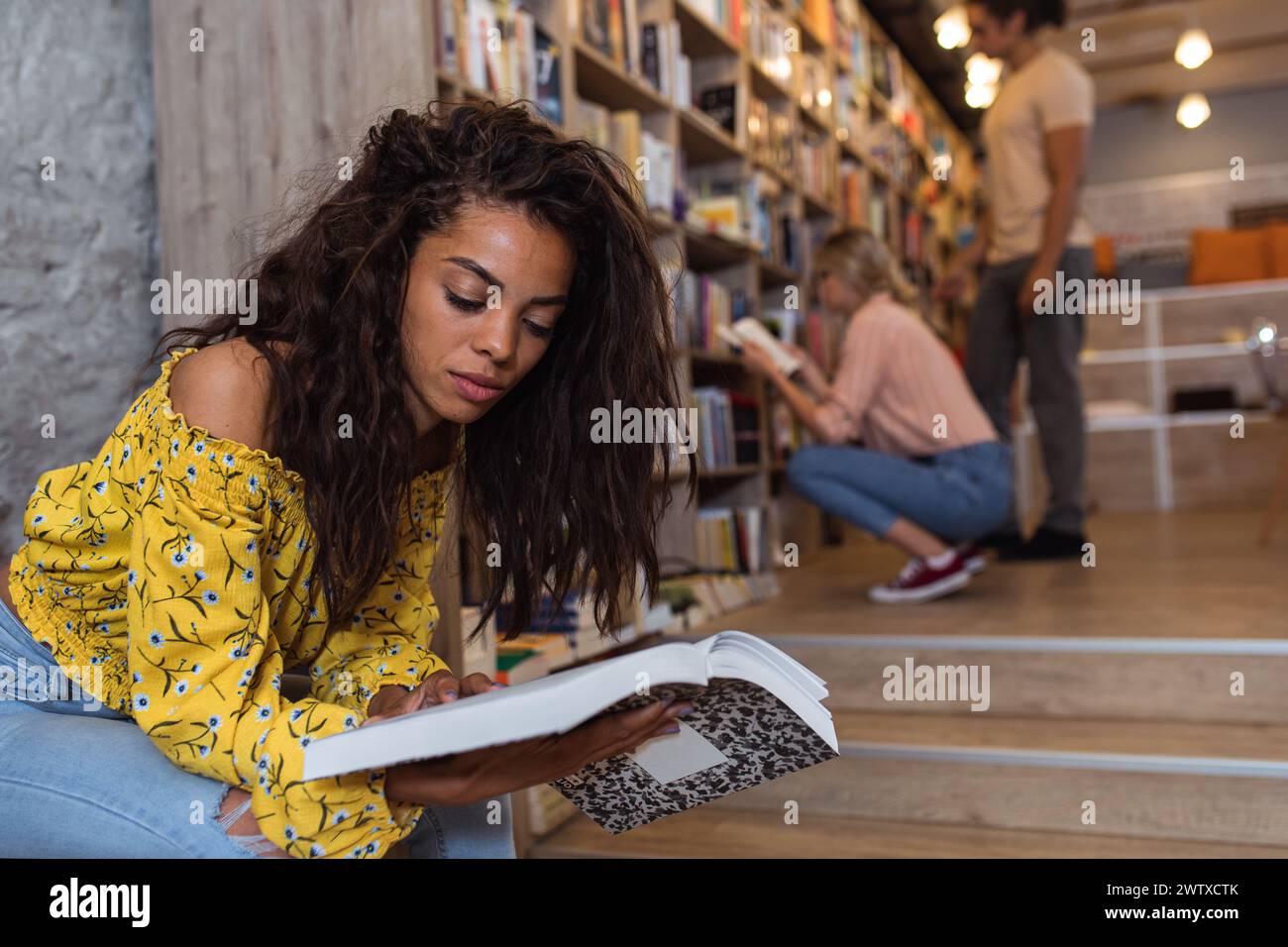 Young female student study in the library reading book Stock Photo - Alamy