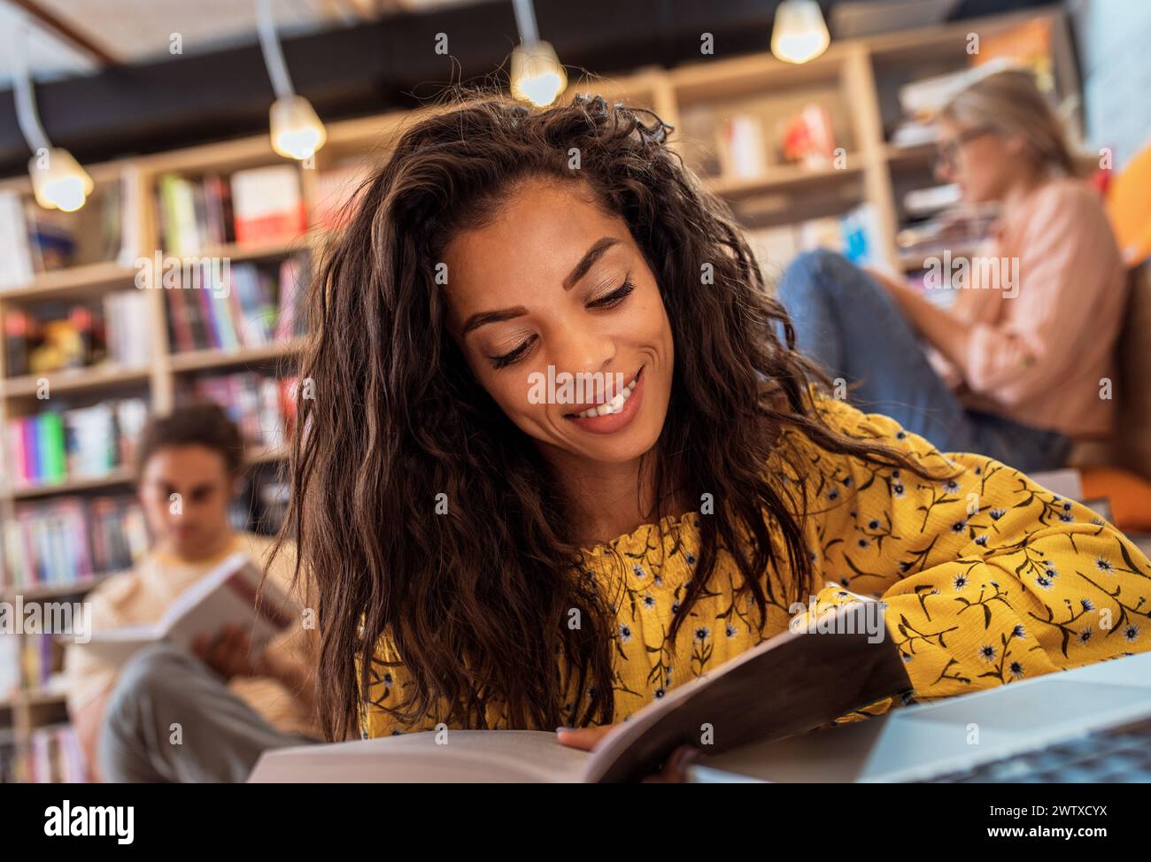 Young female student study in the library reading book Stock Photo - Alamy
