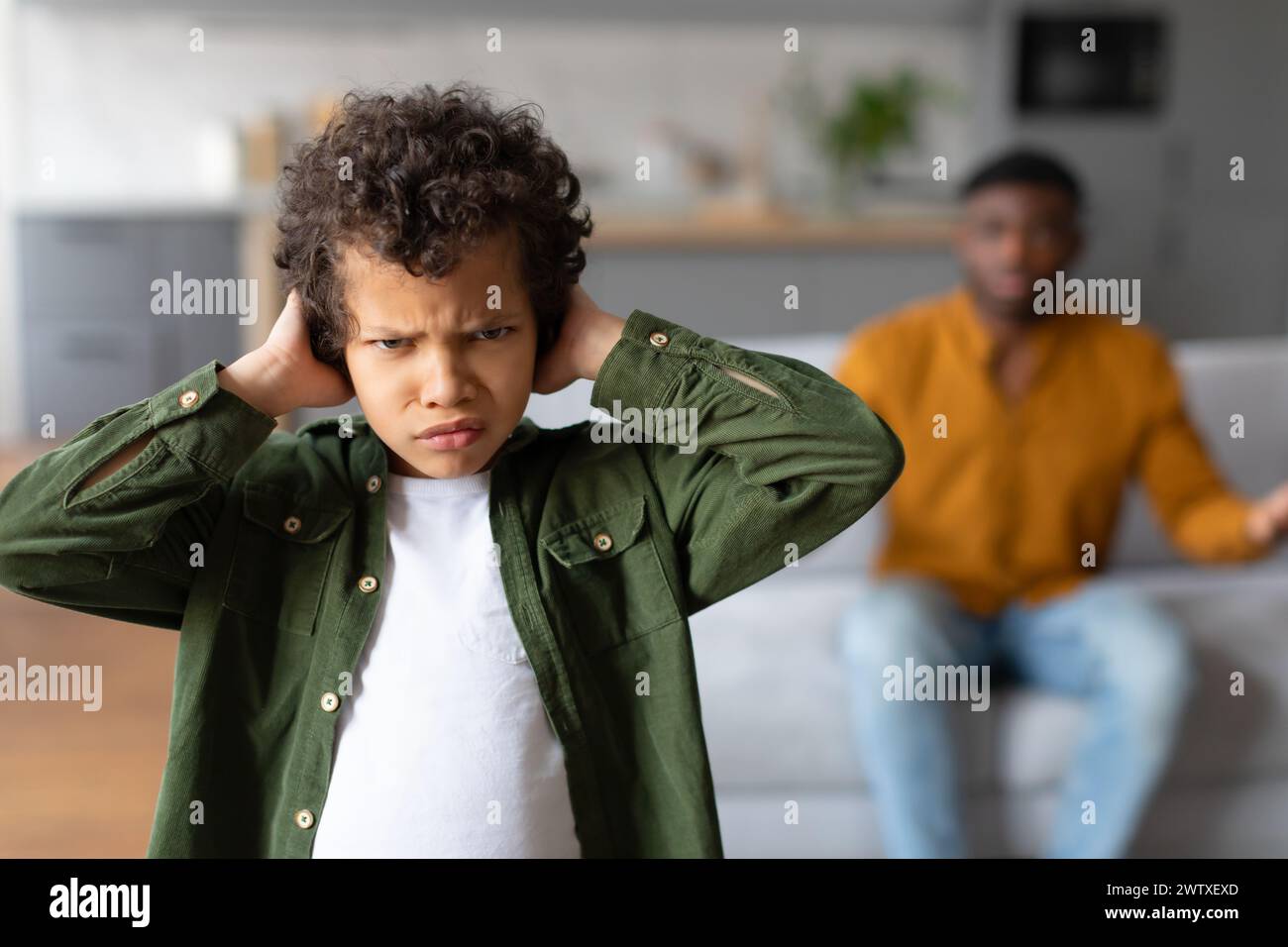Boy with annoyed expression, parents arguing Stock Photo - Alamy