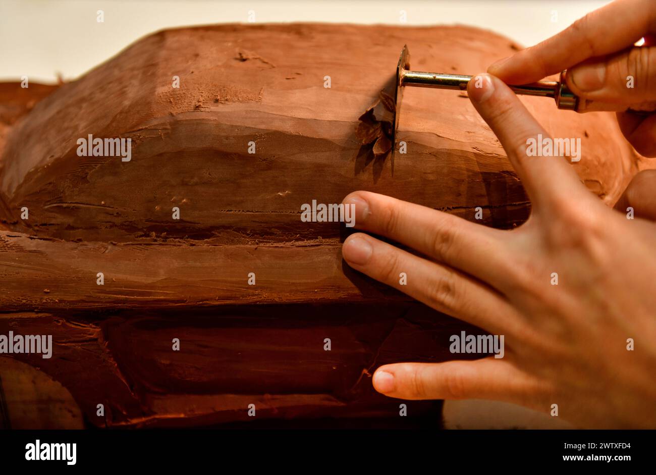 Designers work on the car's sculpture using carving tools. Adjust the ...