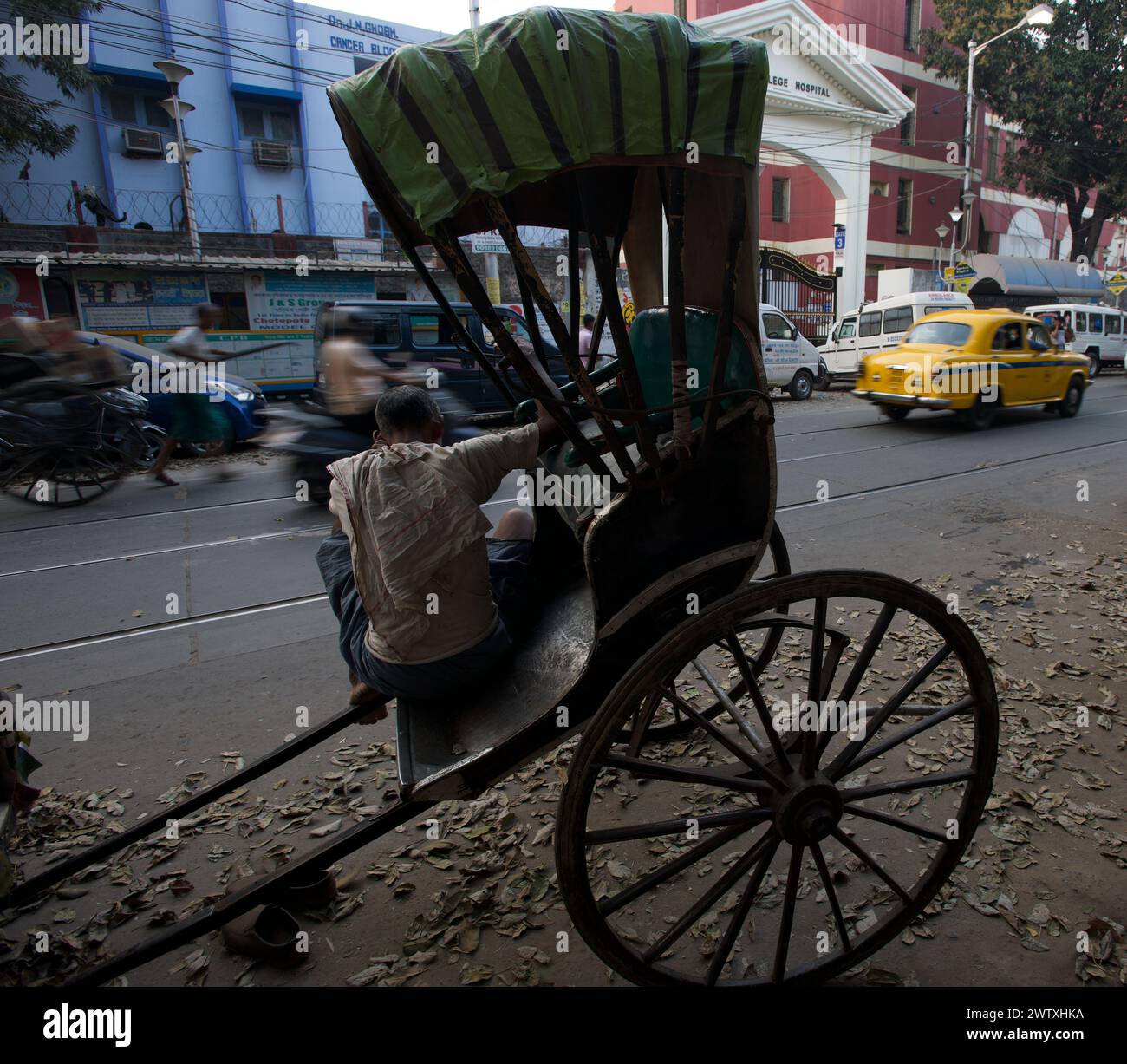 A sat rickshaw driver waiting for customers by a road in Kolkata, West ...
