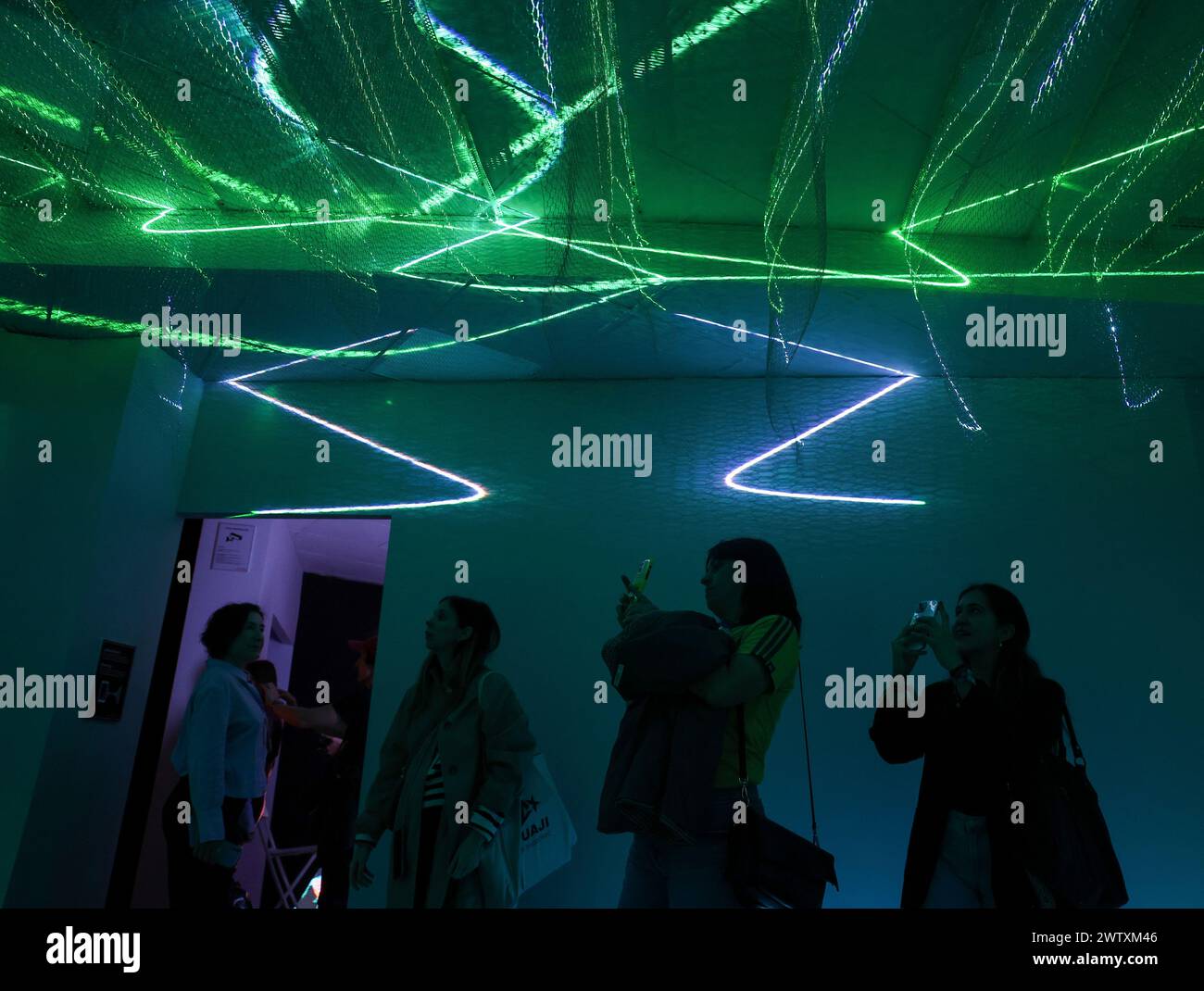 Several people look at one of the installations of the Museum of Light ...