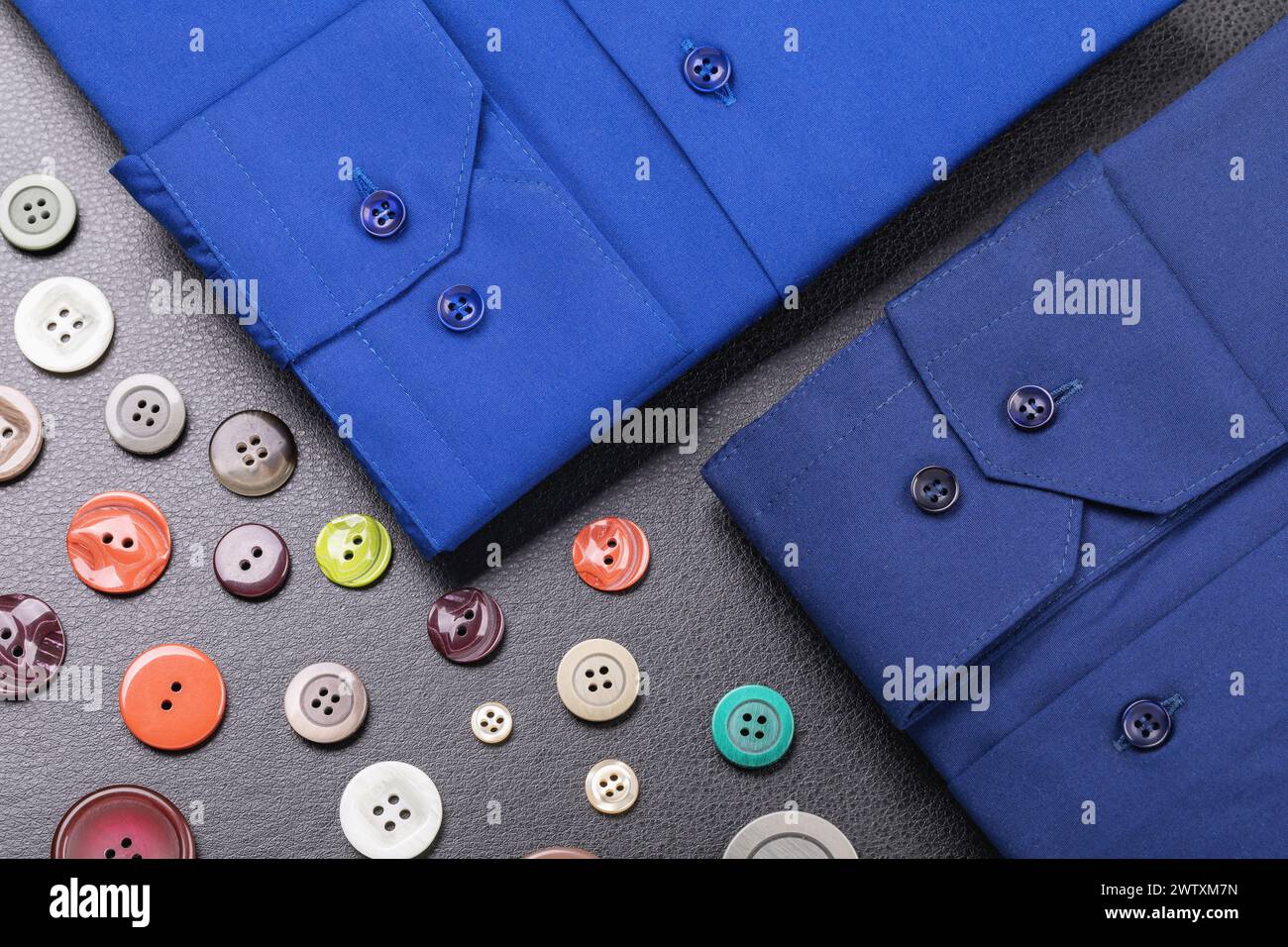 Cuffs of folded shirt sleeves and buttons on a dark background, concept ...