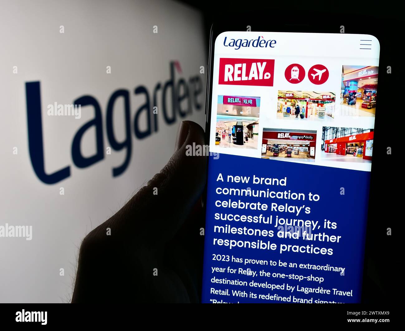 Person holding cellphone with webpage of French publishing and retail ...