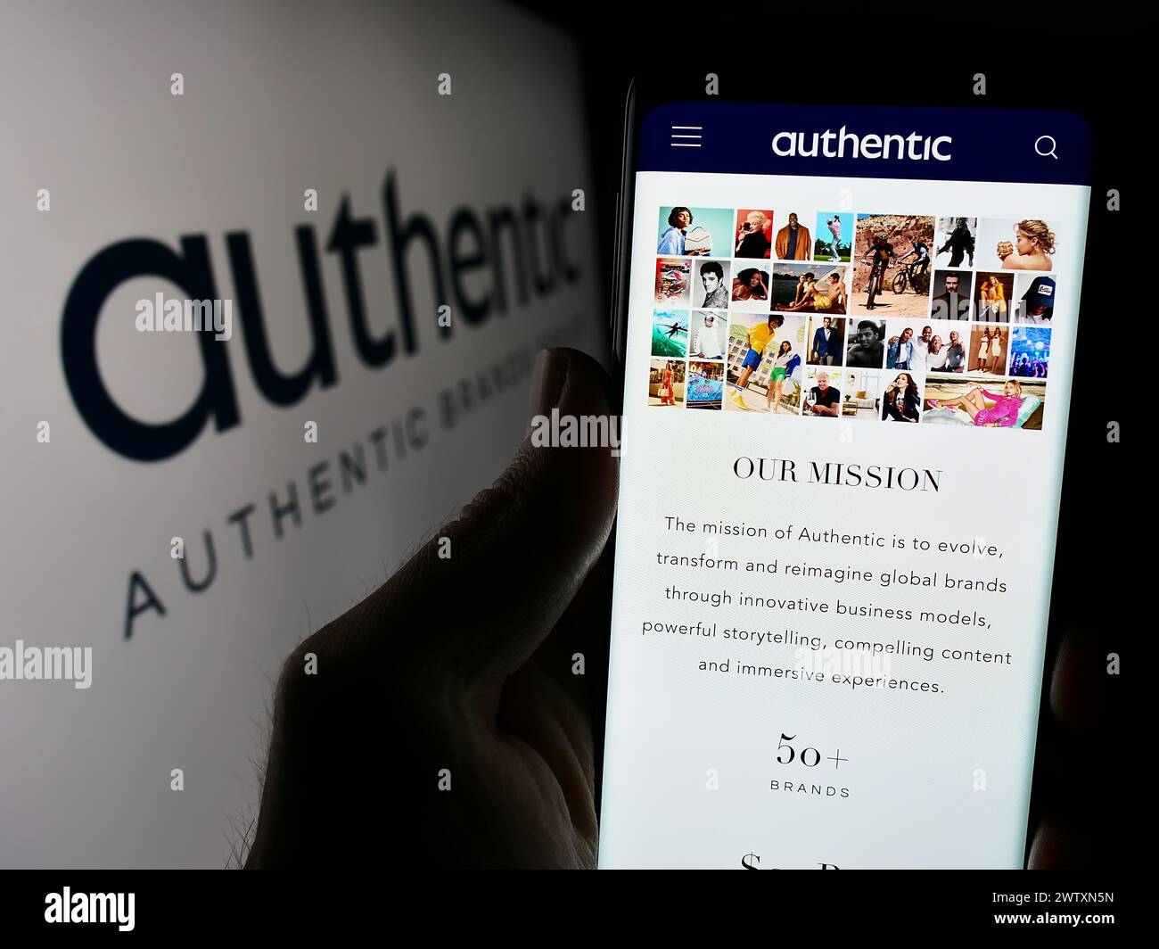 Person holding smartphone with website of US company Authentic Brands ...
