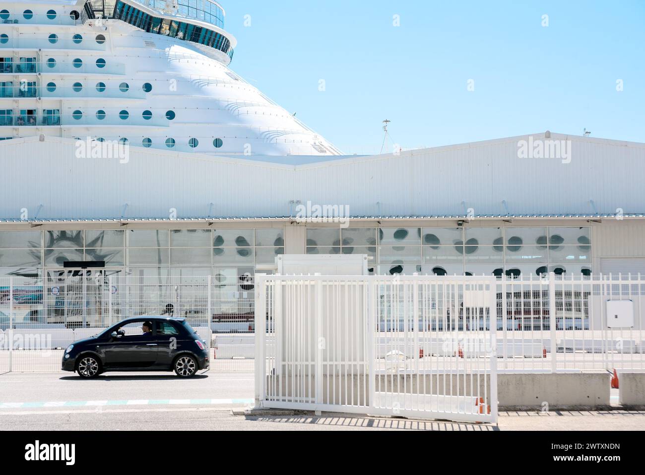Small black car passing huge moored ship Stock Photo - Alamy