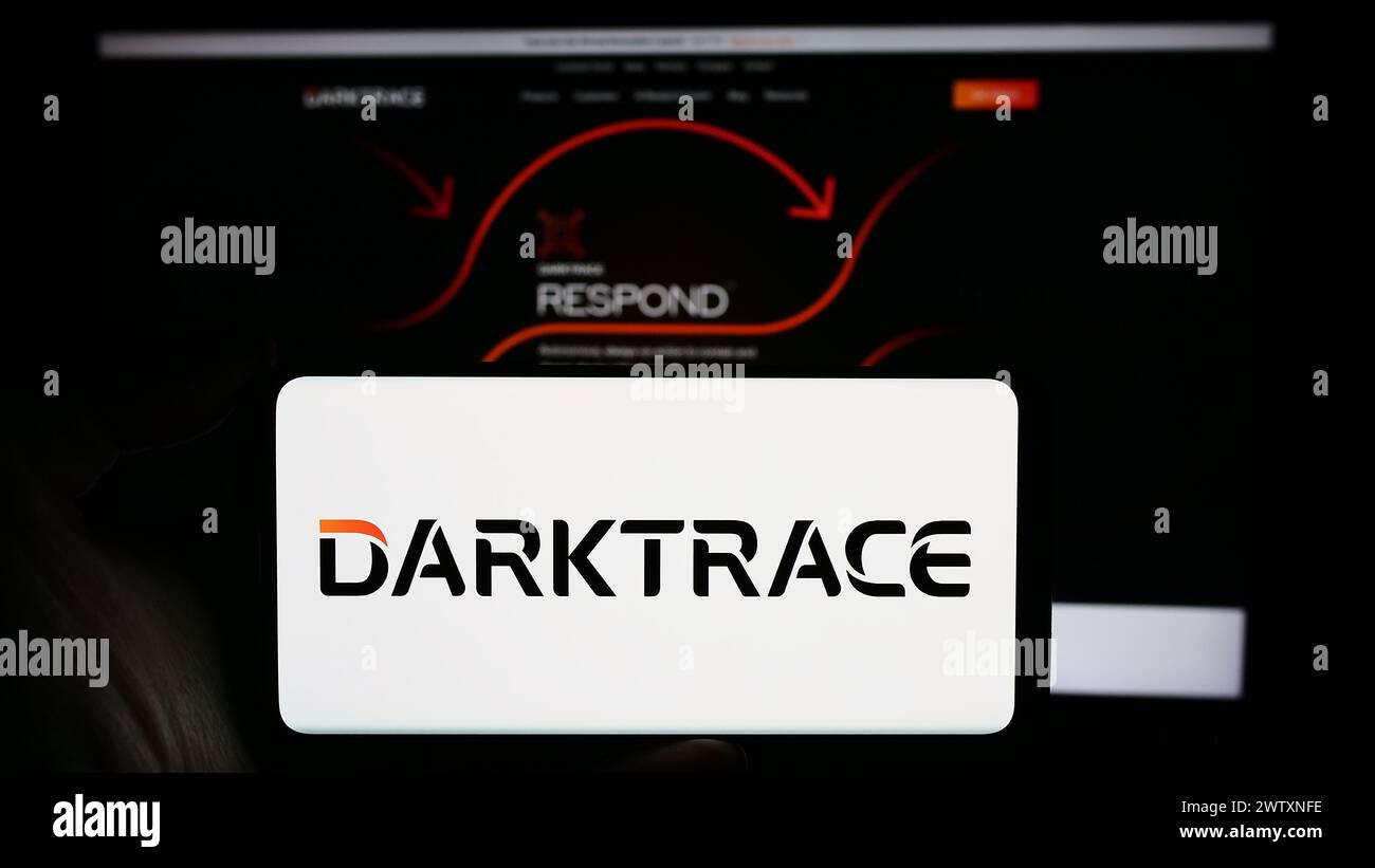 Person holding cellphone with logo of British cyber security company ...