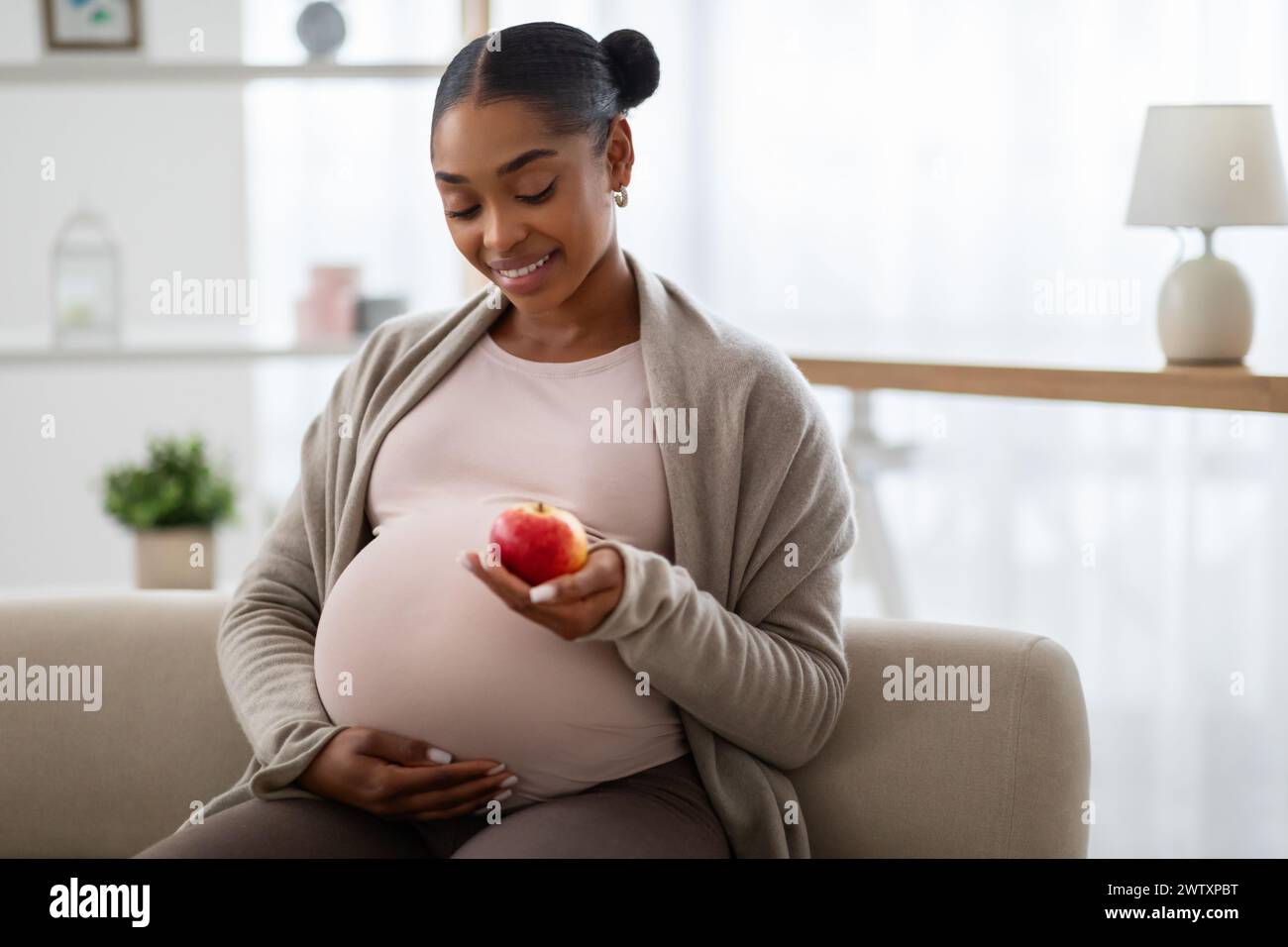 Positive healthy expecting african american woman eating apple Stock ...