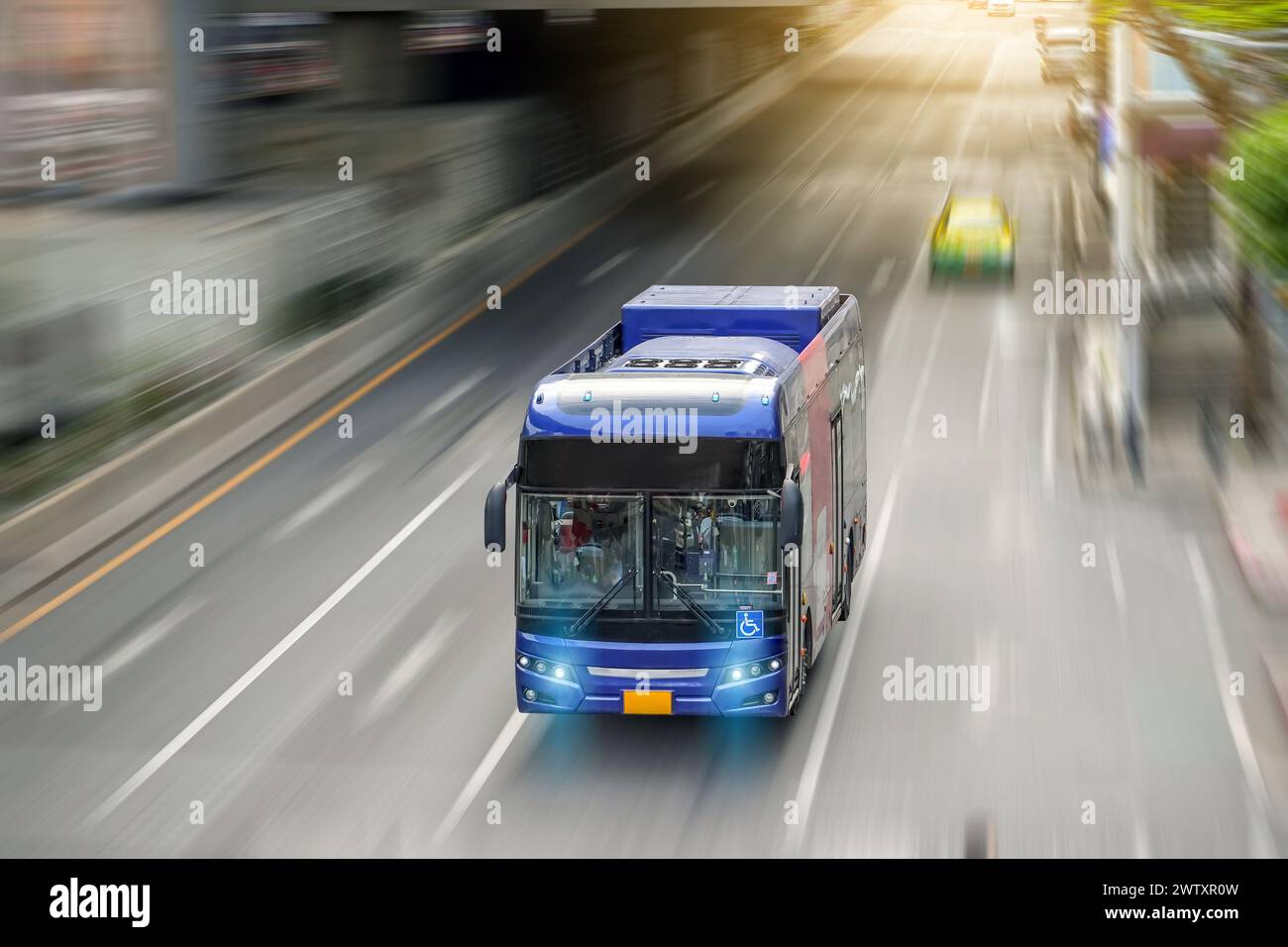 City bus rides along a metropolis street with its headlights on with ...