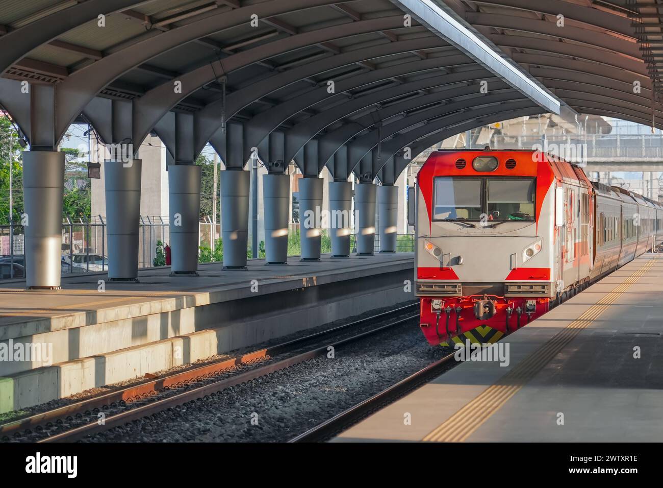 Long-distance train arrives at a transit passenger suburban station ...