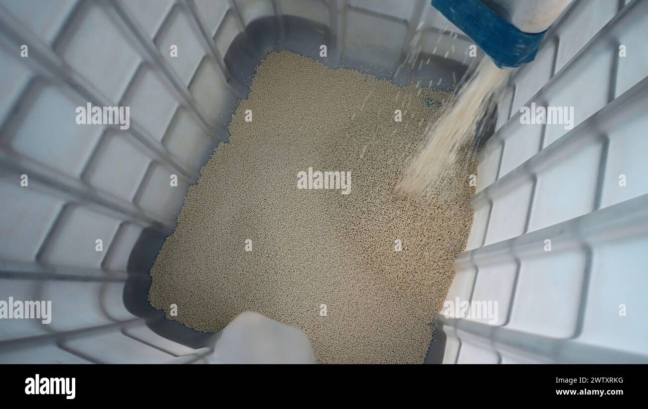 Pouring pile of plastic particles. Creative. Process of filling ...