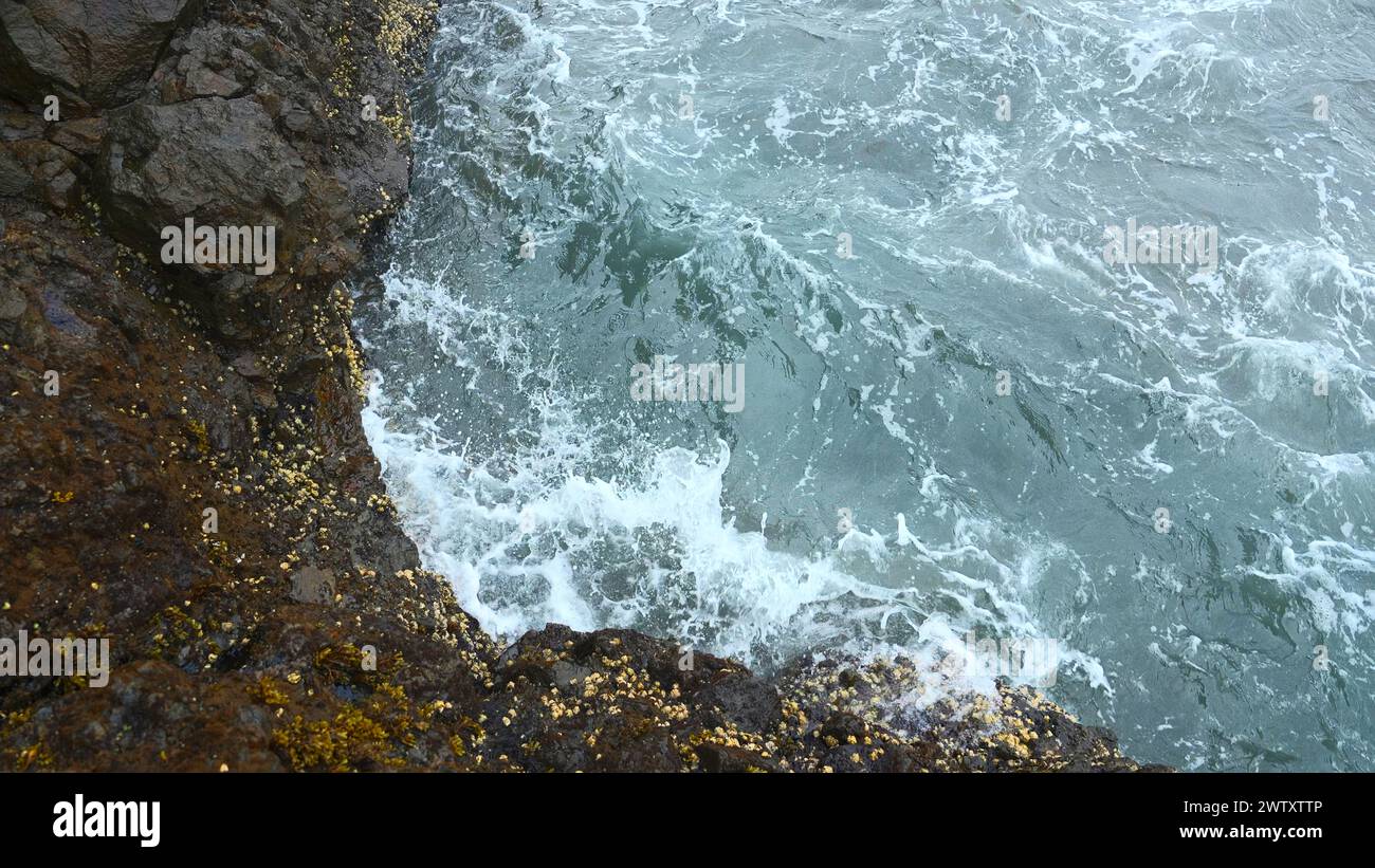 Close-up of surge of waves on rocky shore. Clip. Beautiful waves with ...