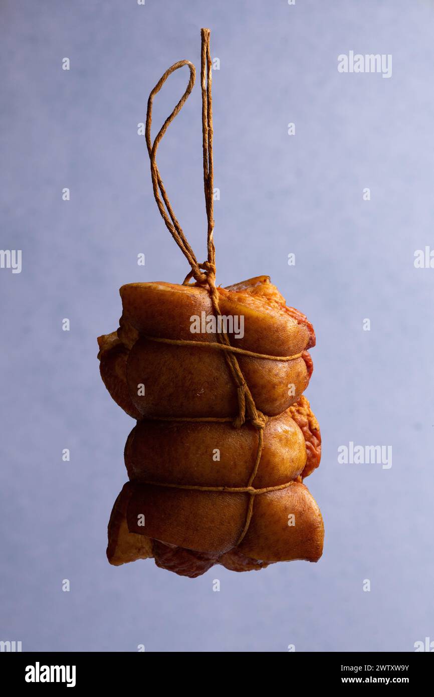smoked spicy pork roll levitates on blue background Stock Photo - Alamy