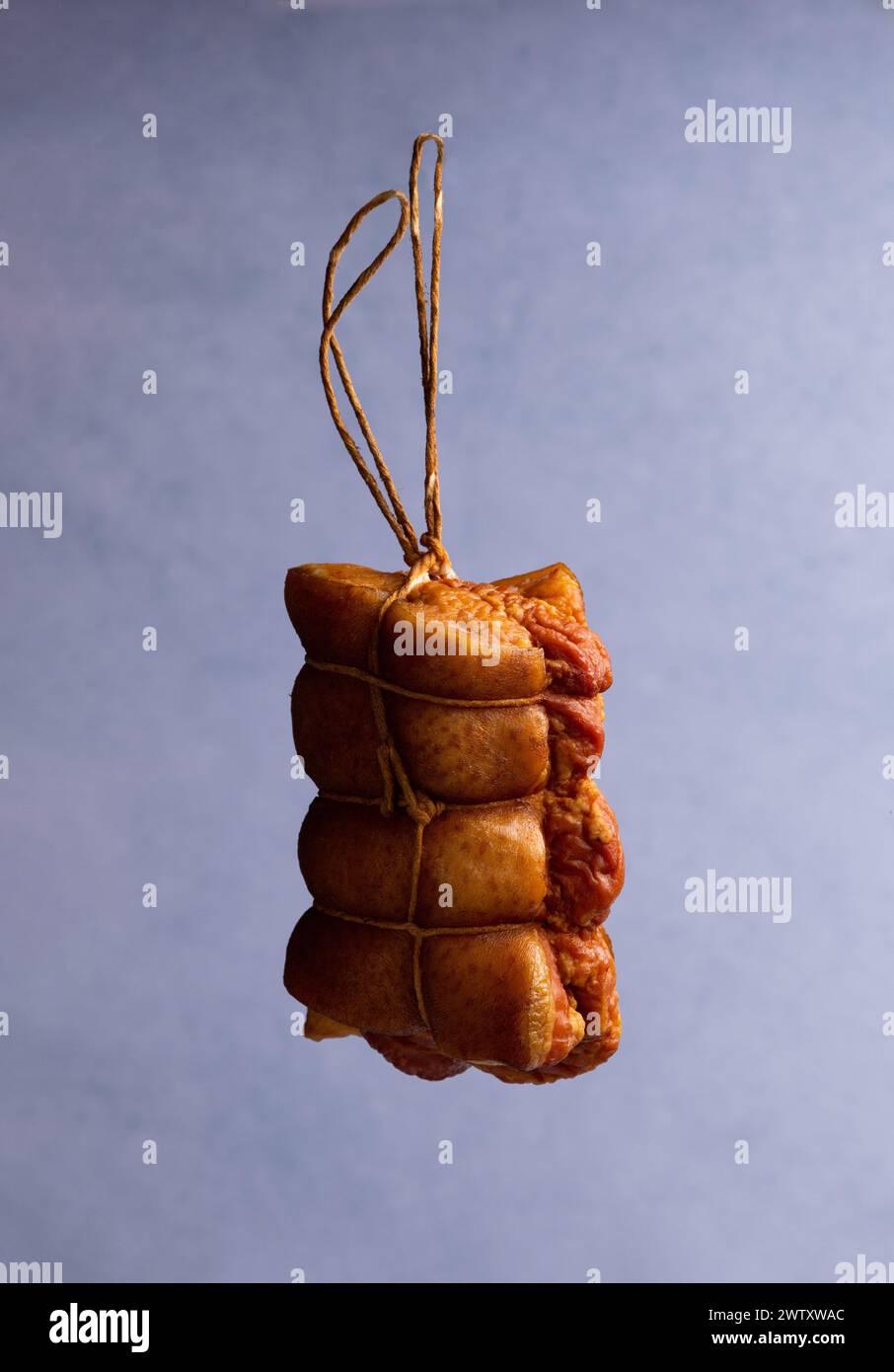 smoked spicy pork roll levitates on blue background Stock Photo - Alamy