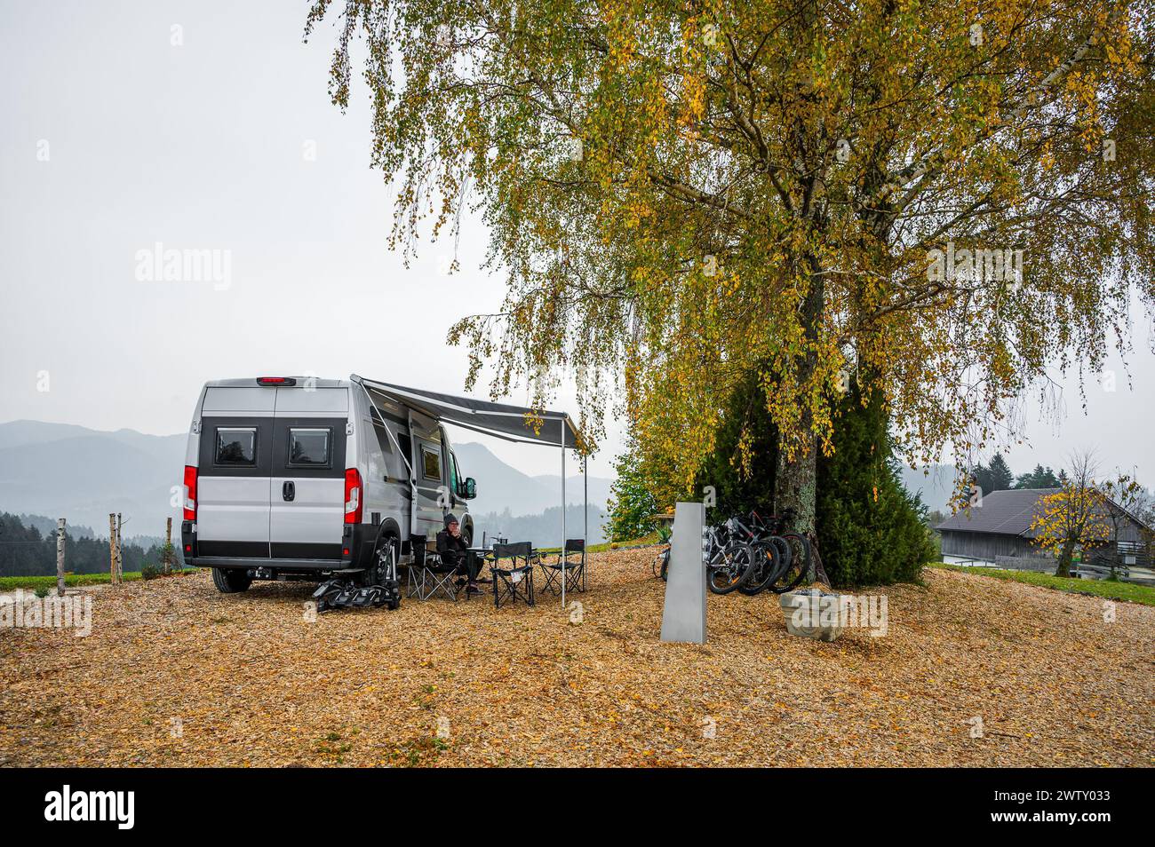 Campervan or motorhome parked in the countryside nature. Woman is ...