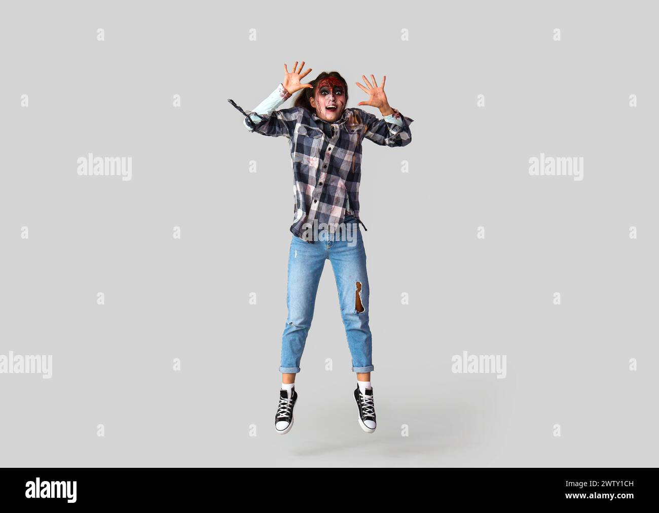 Scary zombie woman jumping on grey background Stock Photo - Alamy