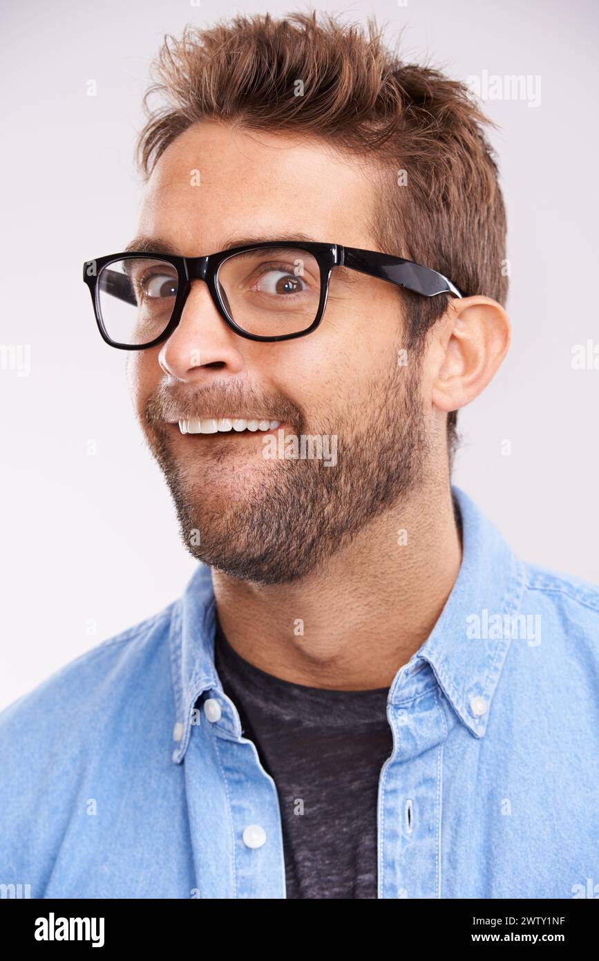 Silly face, nerd and man with glasses, portrait and goofy guy on a grey ...