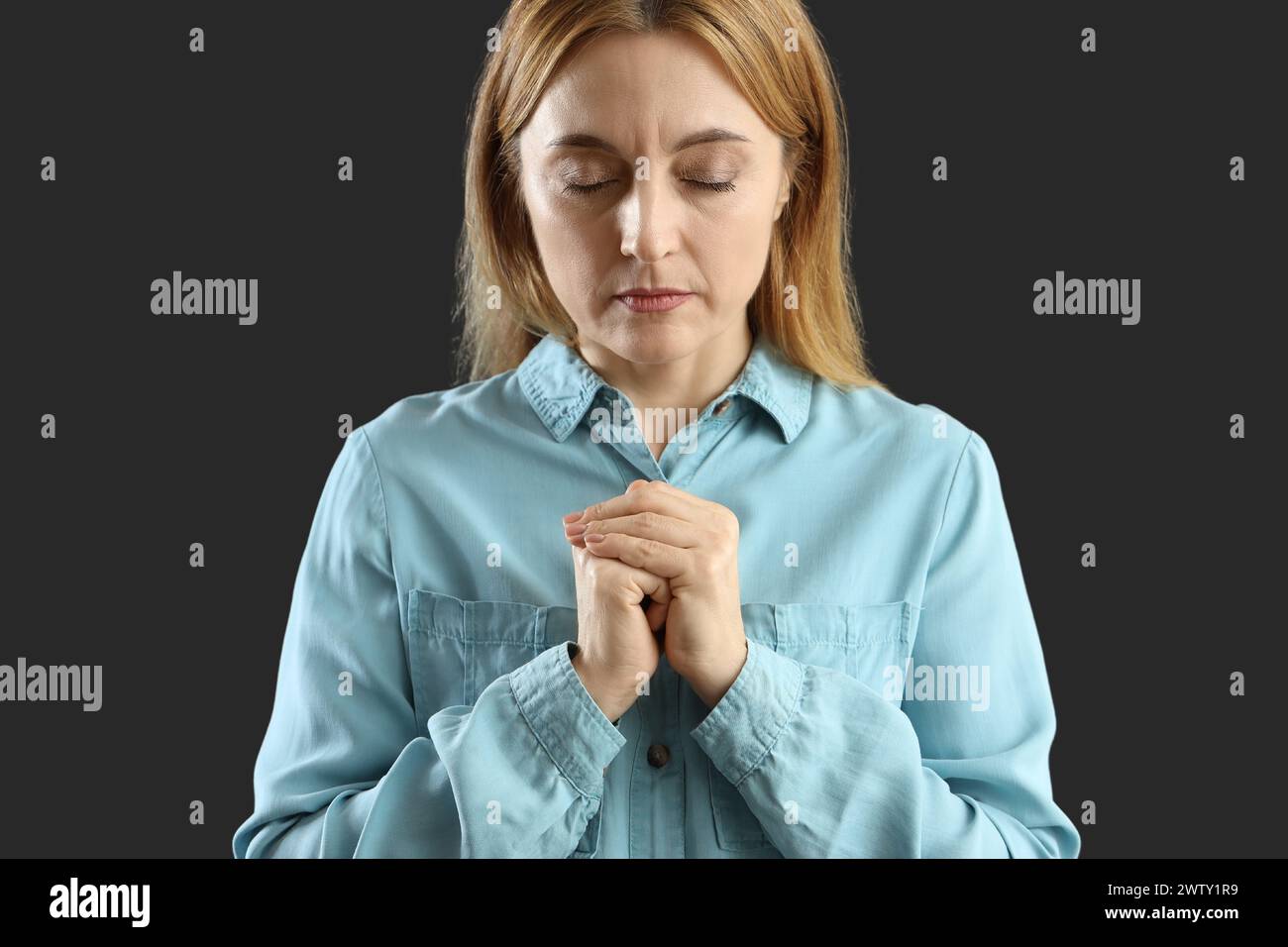 Mature woman praying on dark background, closeup Stock Photo - Alamy