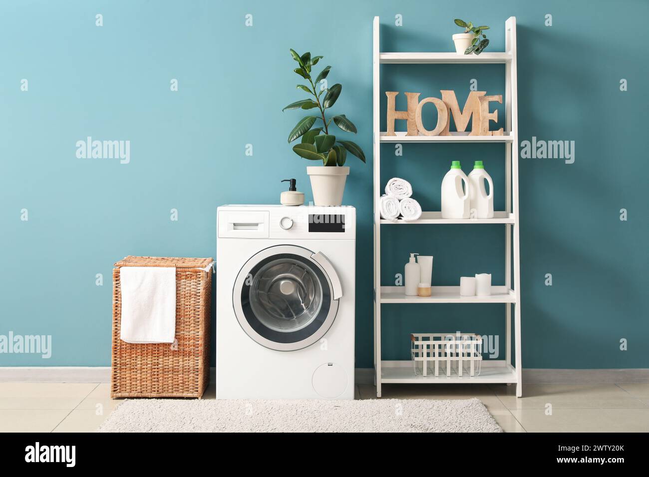 Interior of room with laundry basket, washing machine and shelf unit ...