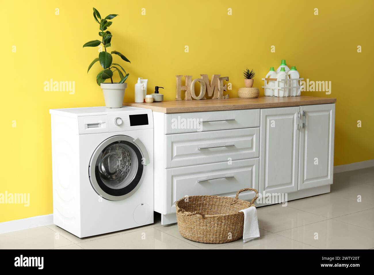Interior of room with laundry basket, washing machine and white ...
