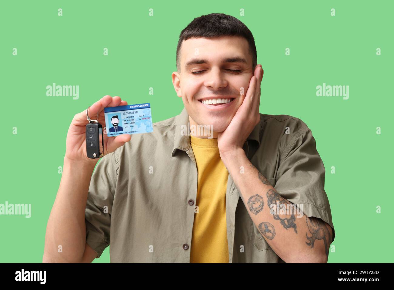 Young happy man holding driver license on green background Stock Photo ...