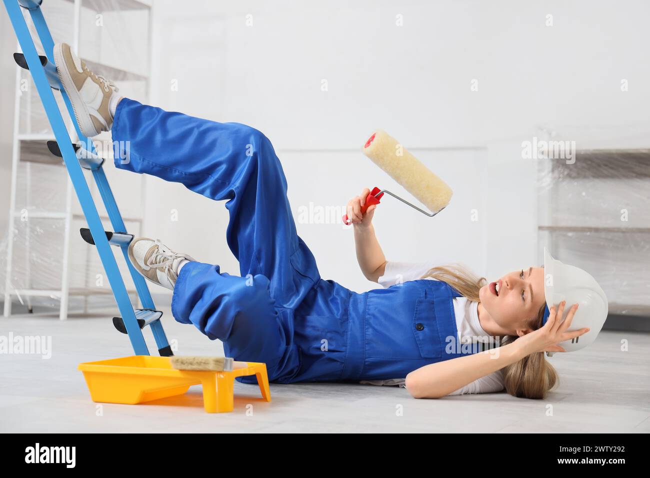 Female painter with roller fell down from stepladder in room. Trauma ...