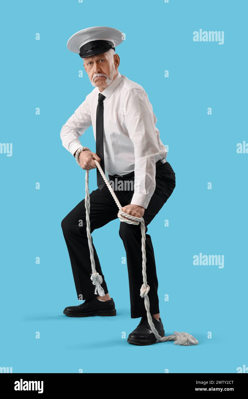 Mature sailor with rope on blue background Stock Photo - Alamy