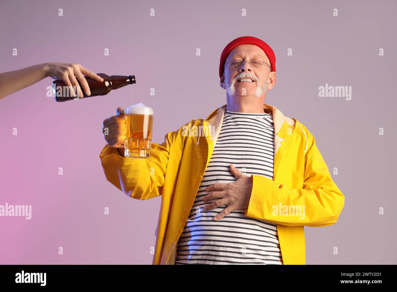 Mature sailor pouring beer on grey background Stock Photo - Alamy