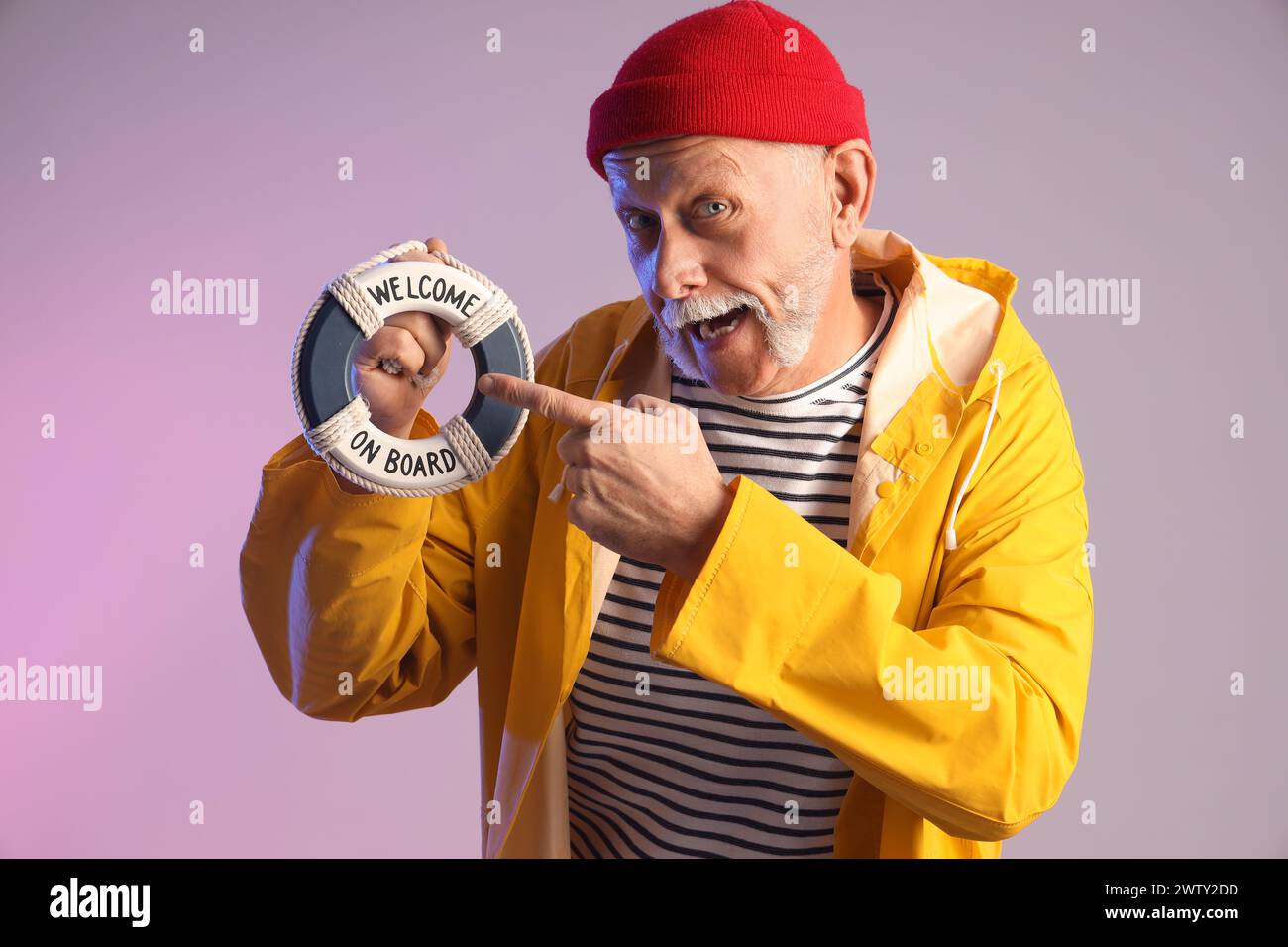 Mature sailor pointing at small ring buoy on grey background Stock ...